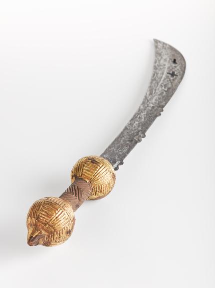 Curved steel ceremonial sword with wooden handle decorated with gold ...