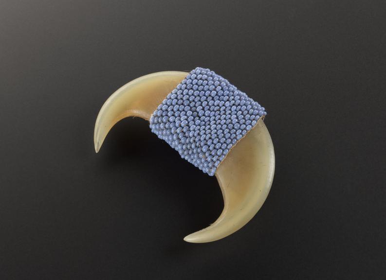 Pendant of two claws joined by cuff of blue beads | Science Museum ...