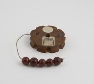 Grooved disc with five spherical beads attached by a thread | Science ...