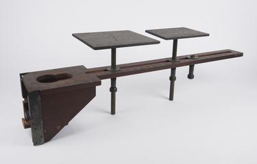 Open ended box attached to slotted beam with three adjustable stands ...