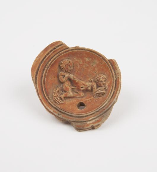 Broken terracotta lamp cover with moulded design of copulating couple ...