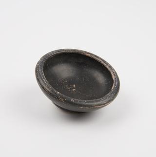 Small shallow black-glazed dish | Science Museum Group Collection