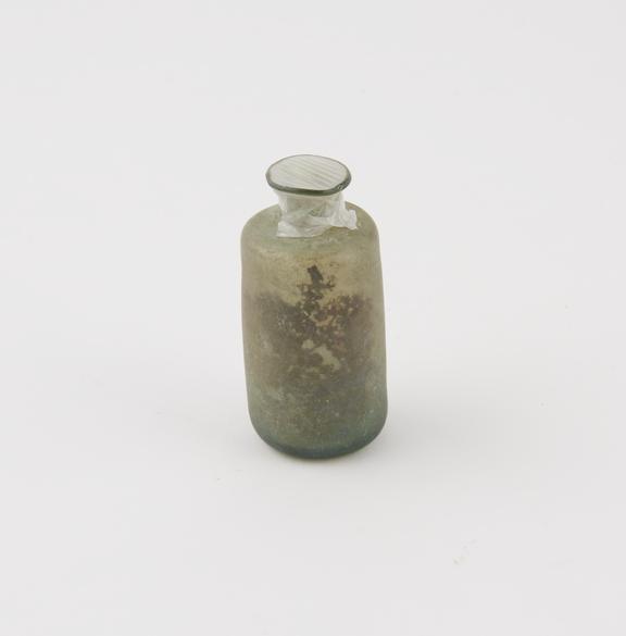 Iridescent green cylindrical glass bottle | Science Museum Group Collection