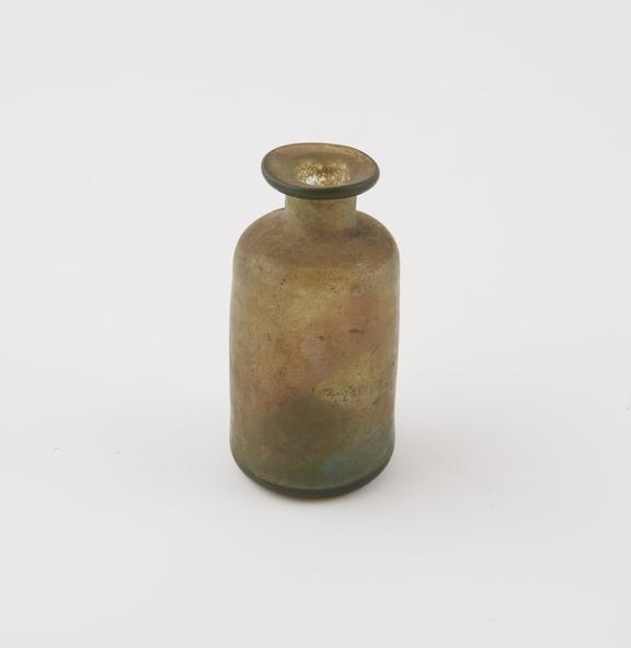 Cylindrical iridescent green glass bottle | Science Museum Group Collection