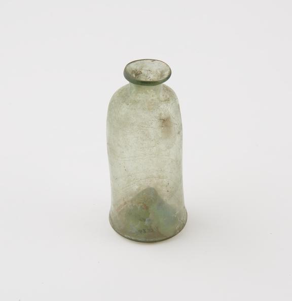 Cylindrical iridescent green glass bottle | Science Museum Group Collection