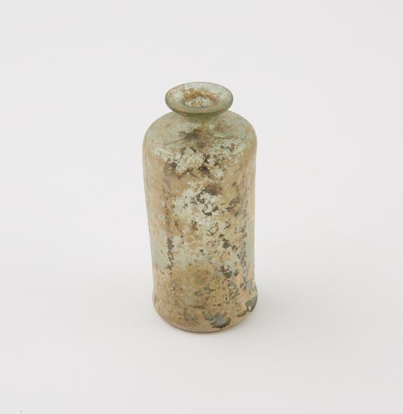 Cylindrical iridescent green glass bottle | Science Museum Group Collection