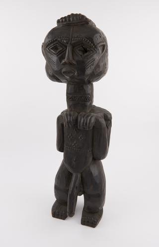 Carved wooden figure with large male genitalia showing facial and body ...
