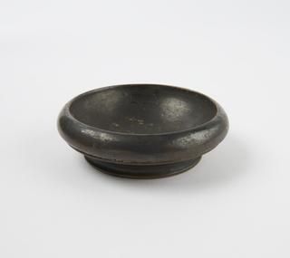 Small shallow black glazed dish | Science Museum Group Collection