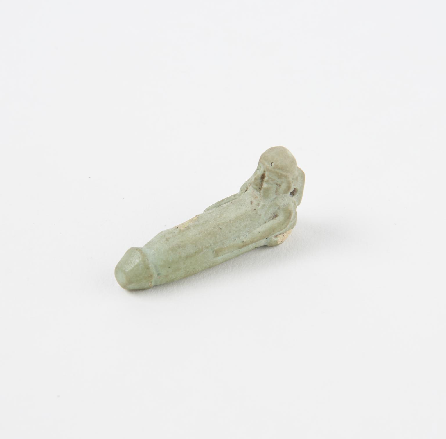 Small glazed green faience amuletic pendant in form of kneeling priapic ...