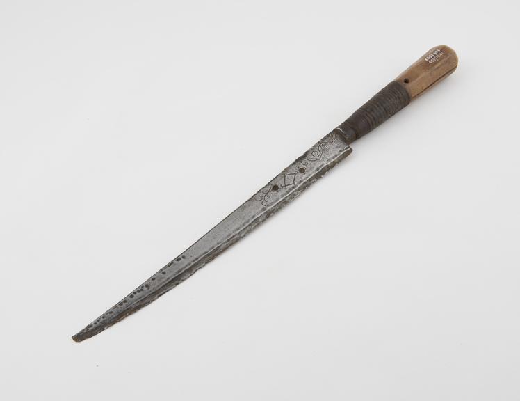Knife with long steel blade decorated with incised curvilinear pattern ...