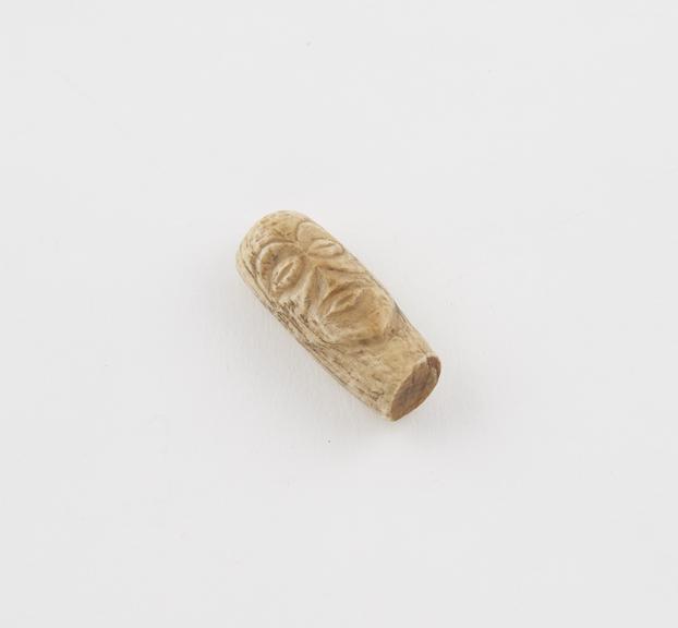 Ivory amulet in the form of a carved face | Science Museum Group Collection