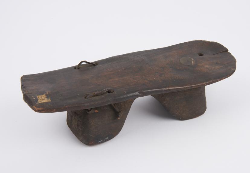 Wooden patten made from single piece of wood with holes for securing ...