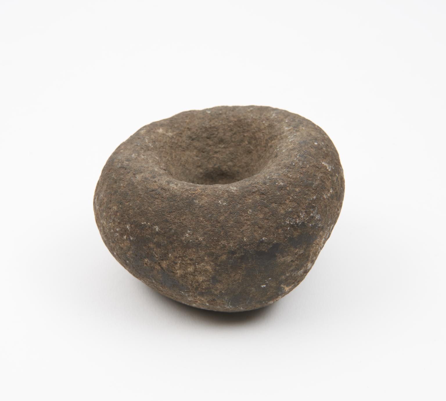 Irregular stone mortar with a conical indentation on both sides ...