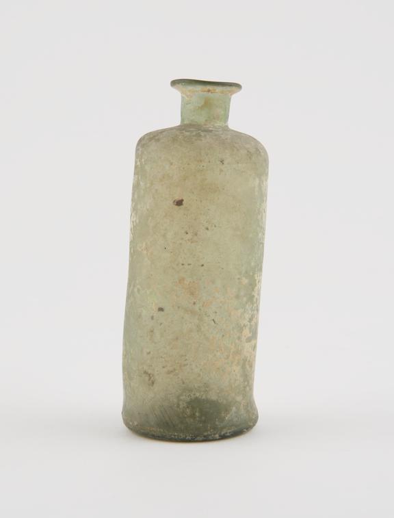 Cylindrical iridescent green glass bottle | Science Museum Group Collection
