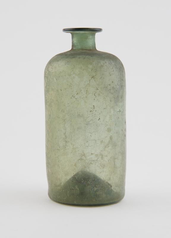 Cylindrical iridescent green glass bottle | Science Museum Group Collection