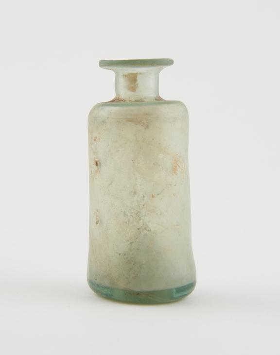 Cylindrical iridescent green glass bottle | Science Museum Group Collection