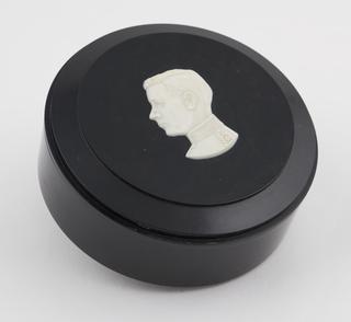 Black circular box decorated with a white head in profile | Science ...