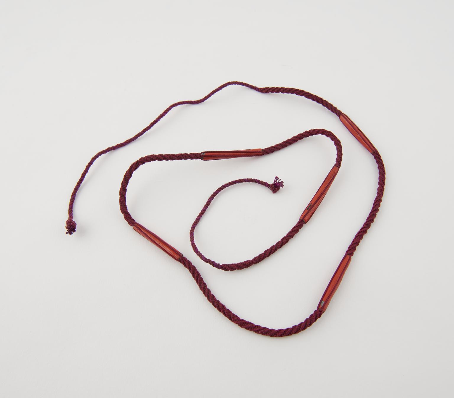 Long silk cord with 5 rolled sheets of lead incorporated into it ...