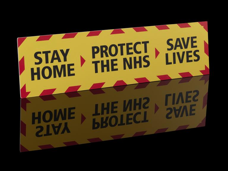 Lectern sign carrying the message 'Stay At Home. Protect the NHS. Save ...