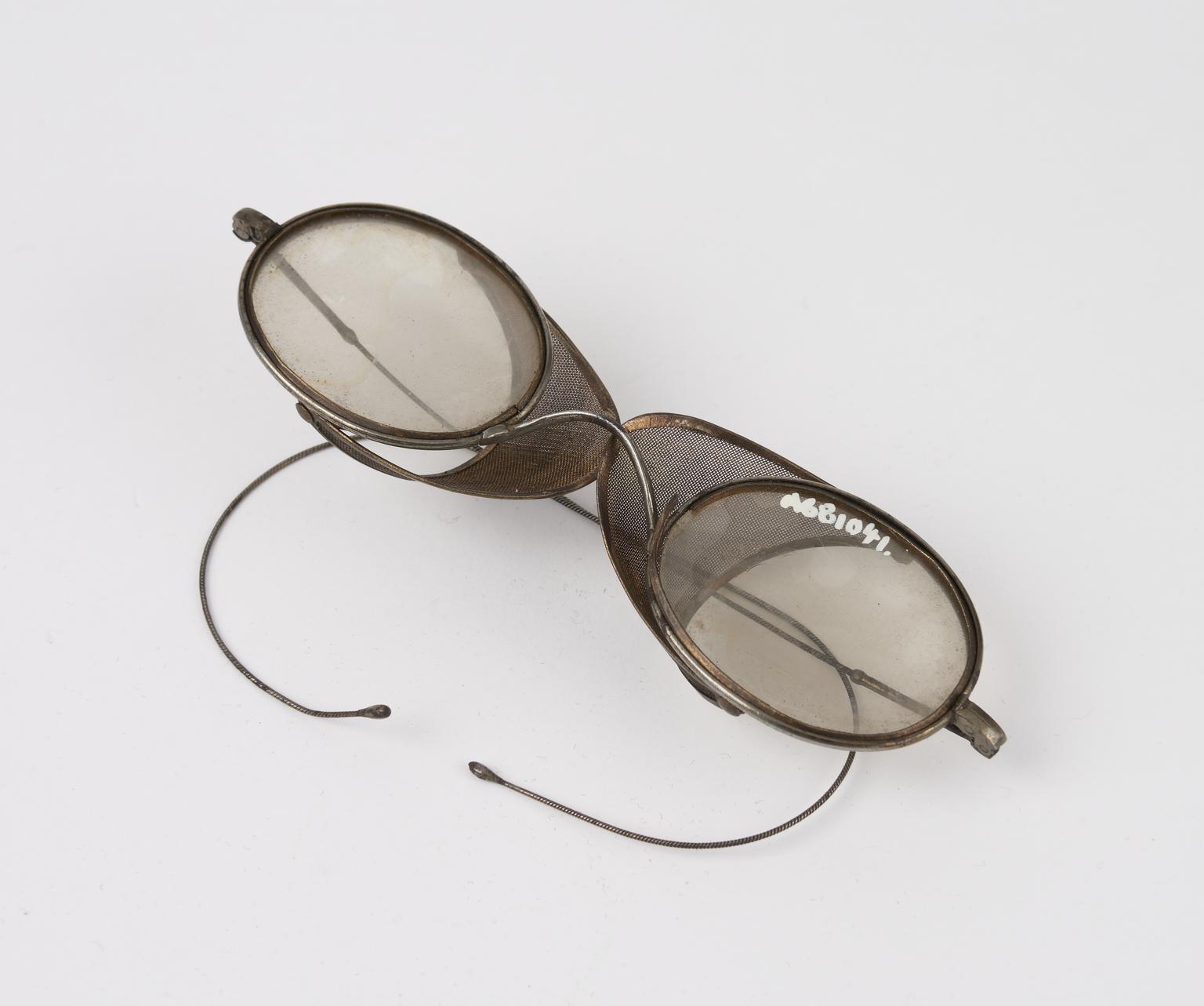 Pair of oval steel-rimmed spectacles with hinged wire mesh shields at ...